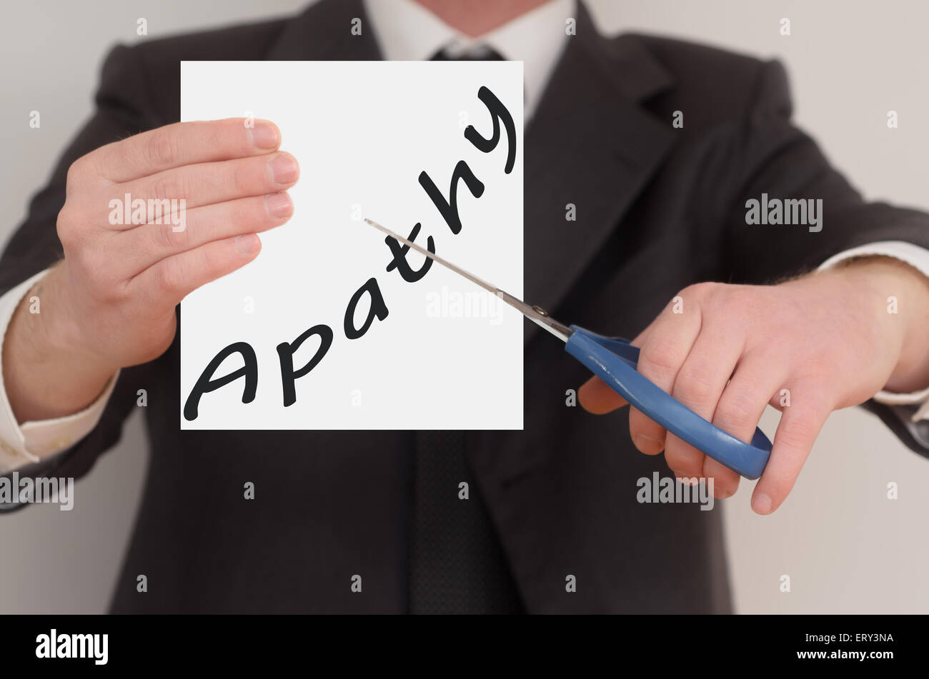 Apathy, man in suit cutting text on paper with scissors Stock Photo - Alamy