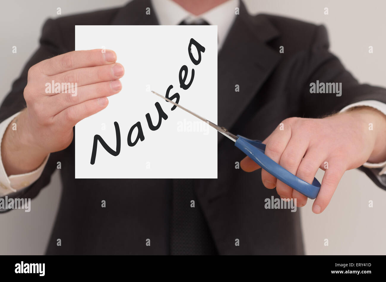 Nausea, man in suit cutting text on paper with scissors Stock Photo - Alamy