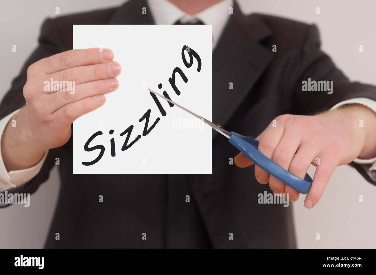 Sizzling, man in suit cutting text on paper with scissors Stock Photo ...