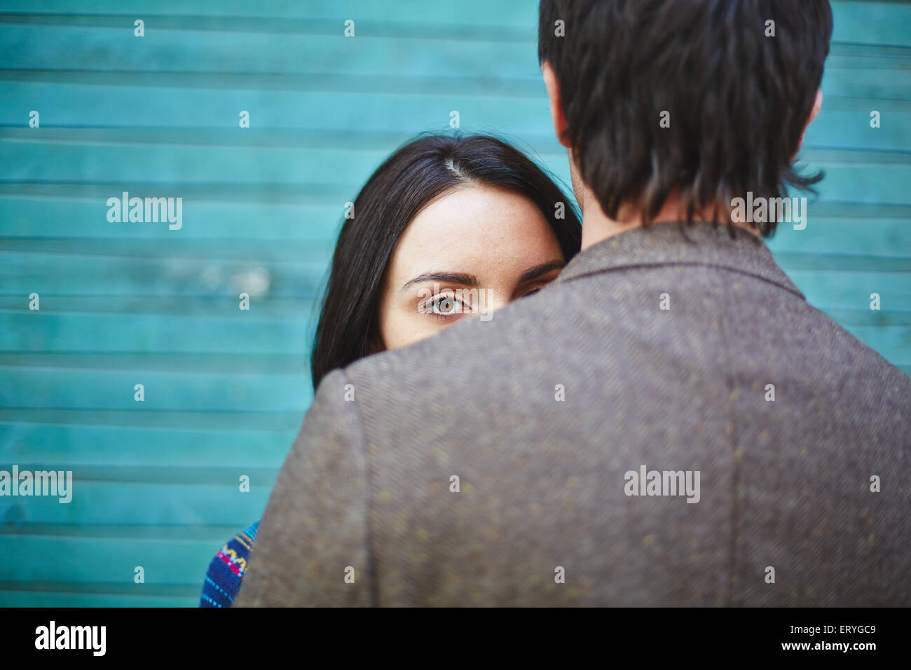 Young woman looking at camera out of man back Stock Photo - Alamy