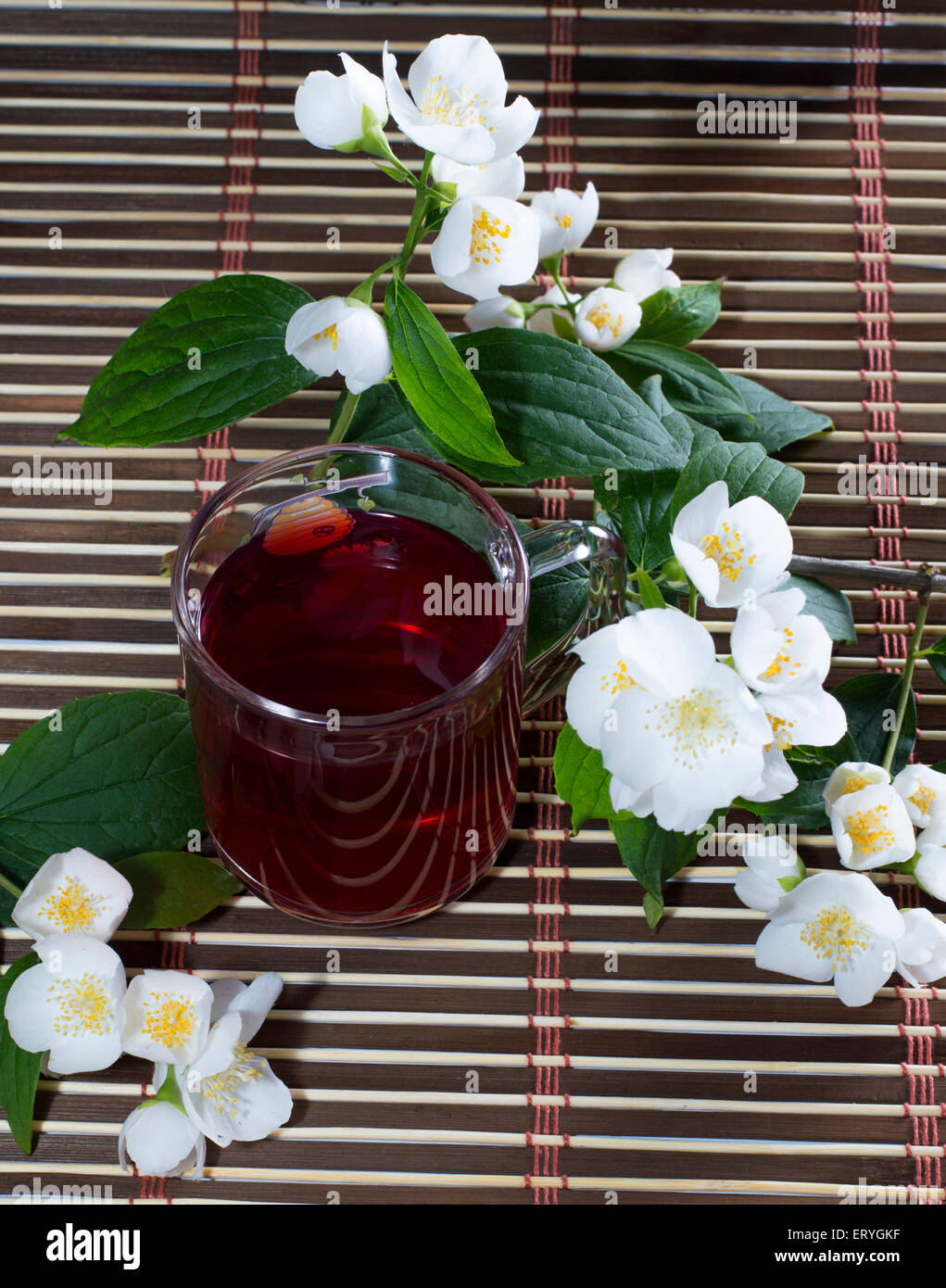 glass of the red tea decorated with flower branches Stock Photo - Alamy
