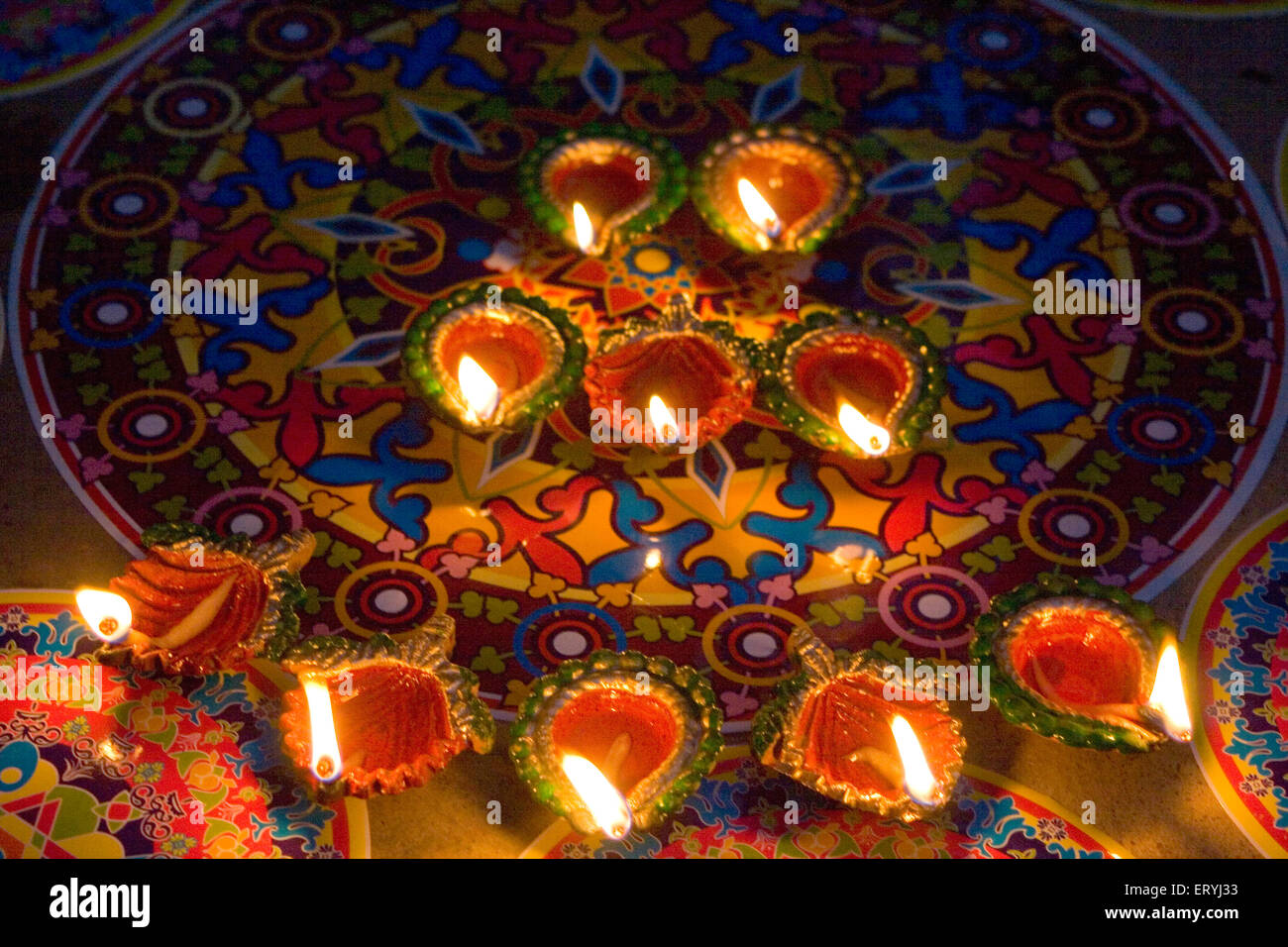 Beautiful colour mat rangoli with oil lamps ; Diwali deepawali festival ...
