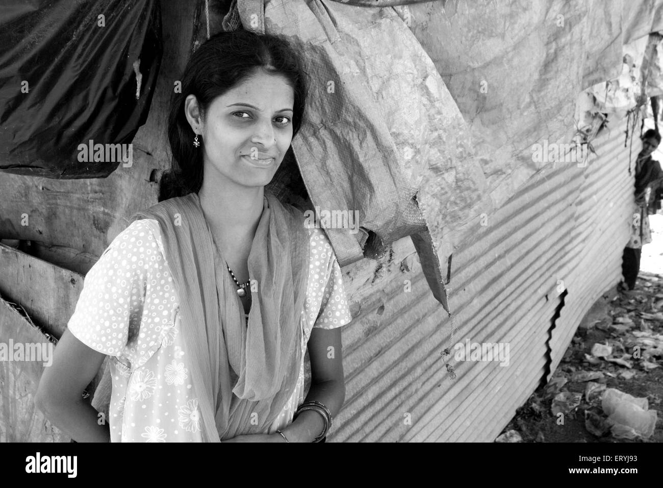 Lady standing outside house in Malvani slum ; Malad ; Bombay Mumbai ...