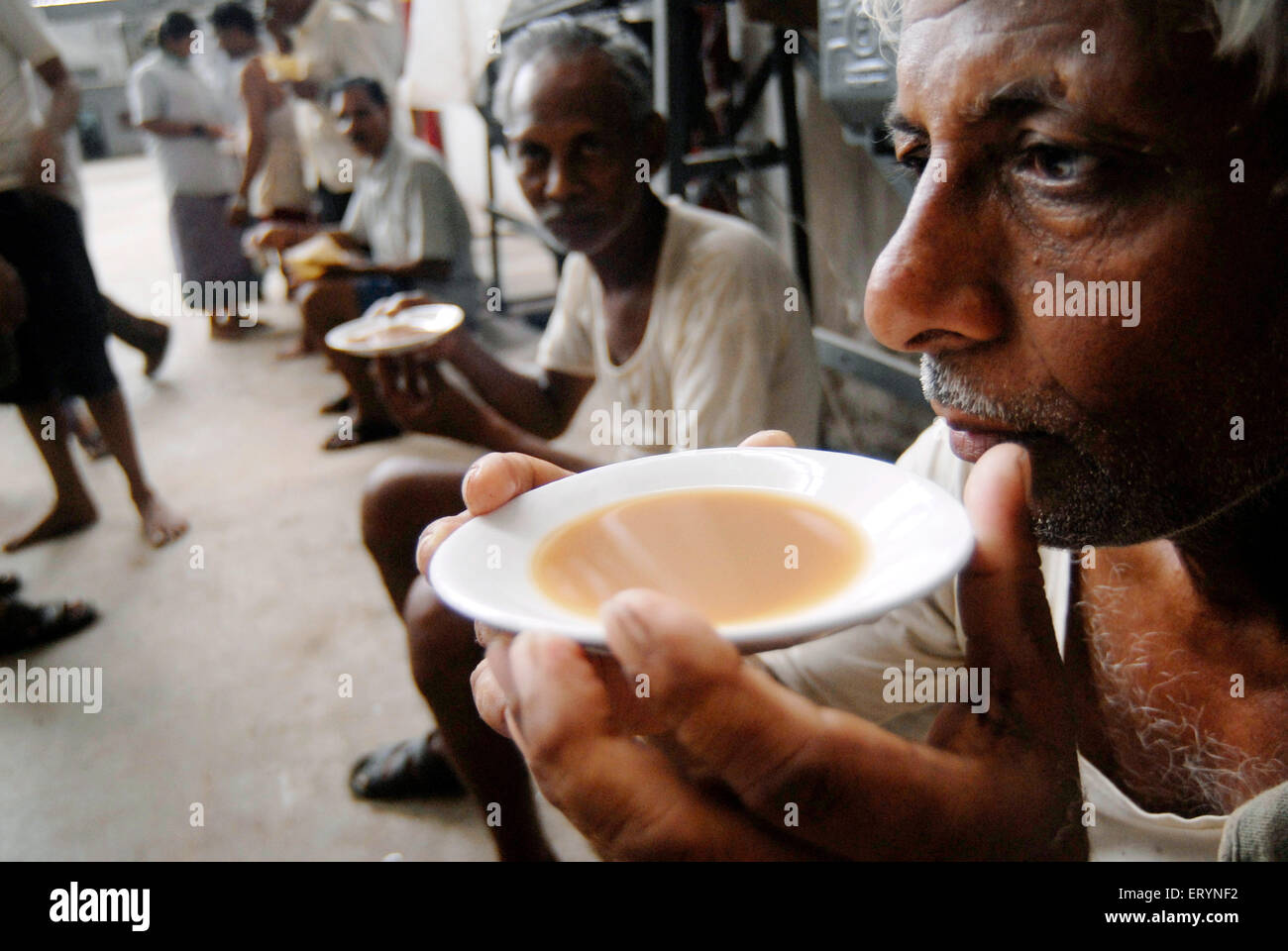 Textile mill worker sip tea during break in a textile mill in Bombay ...