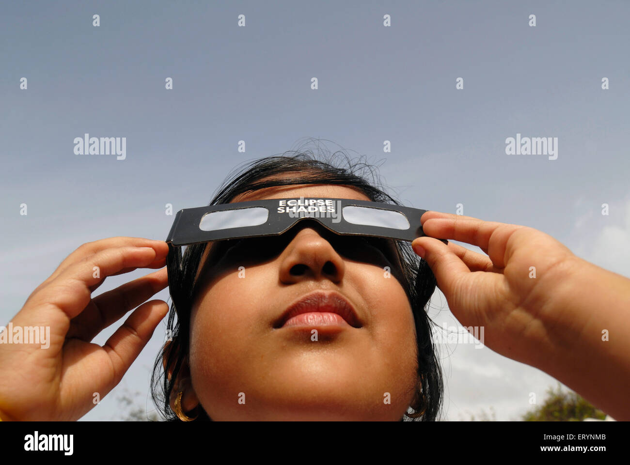 Young girl seeing solar eclipse by wearing a protected filter eclipse ...
