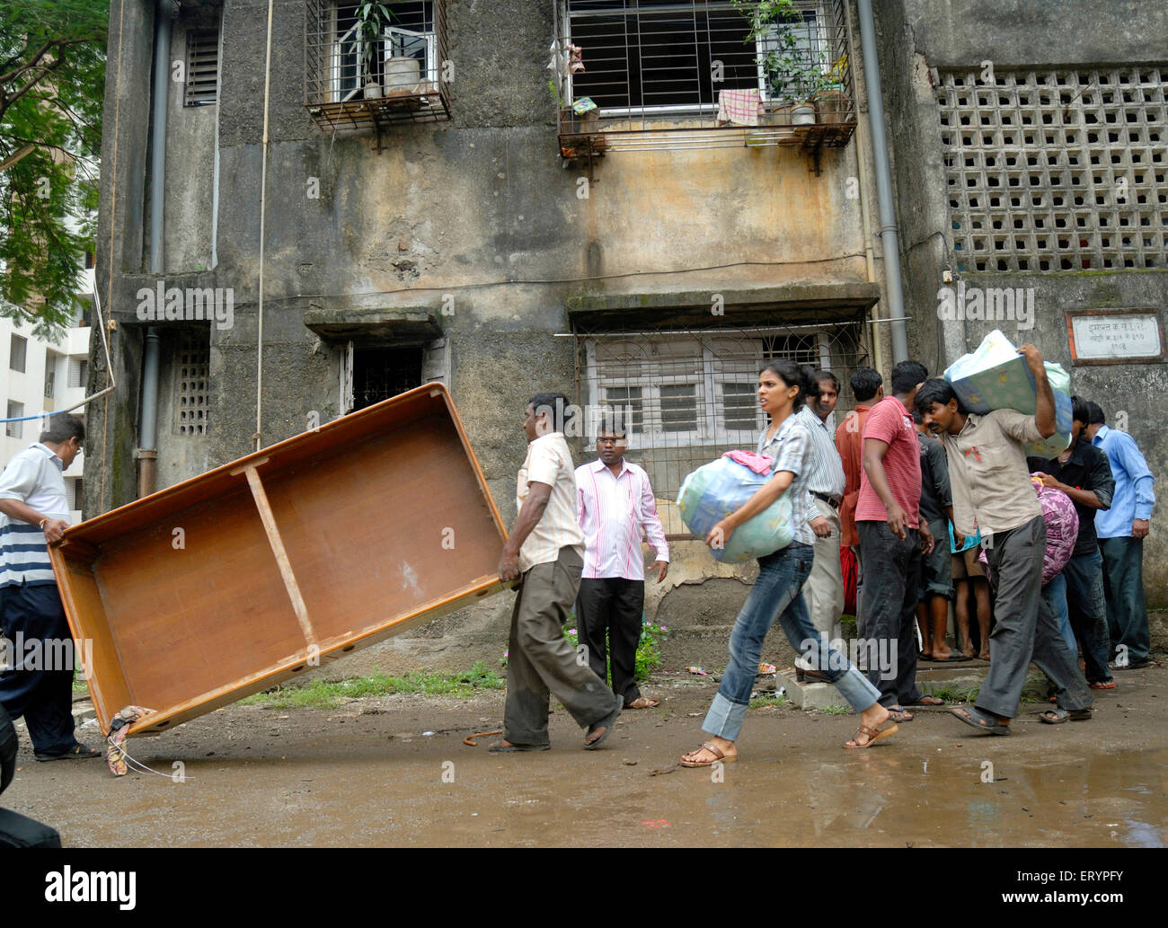 People running with their belongings after old building collapse ...