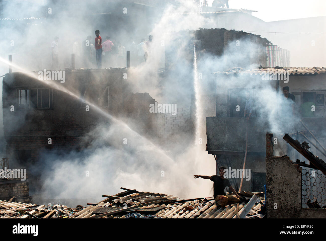Dwellers dousing fire in Behrampada slums ; Bandra ; Bombay Mumbai ...