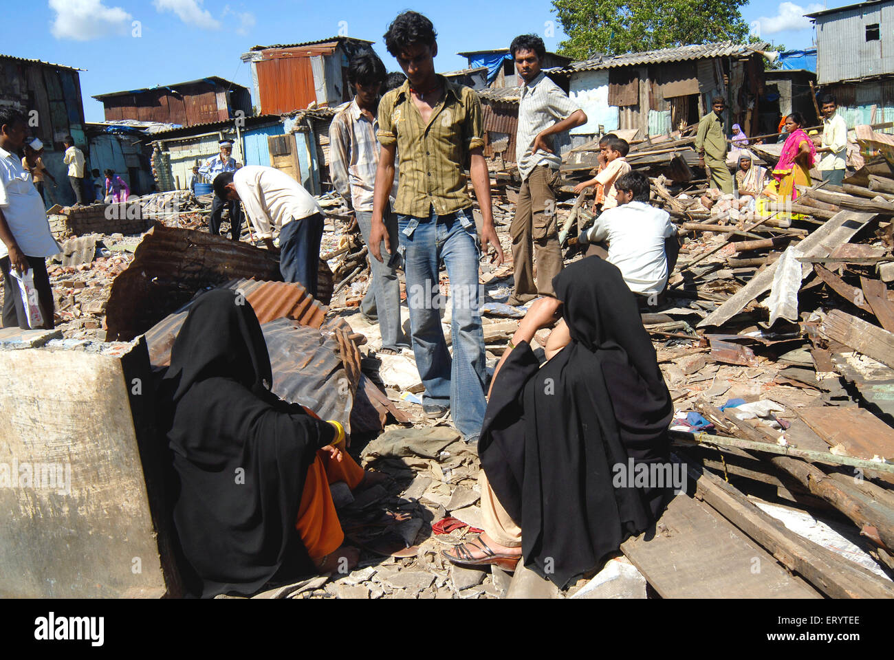 Slum dwellers sit with their belongings after demolition of slums on ...