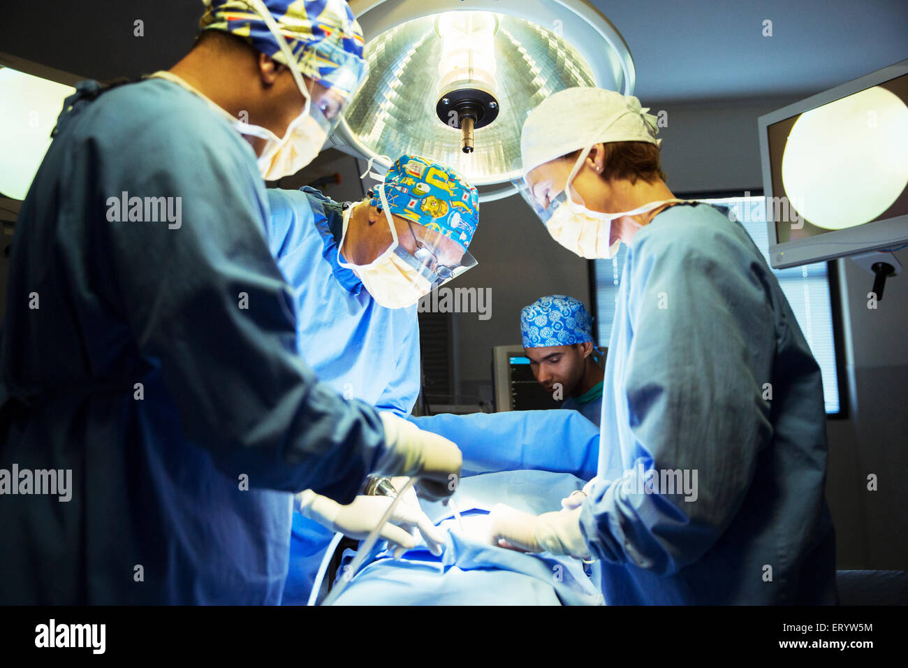Surgeons performing surgery in operating room Stock Photo - Alamy