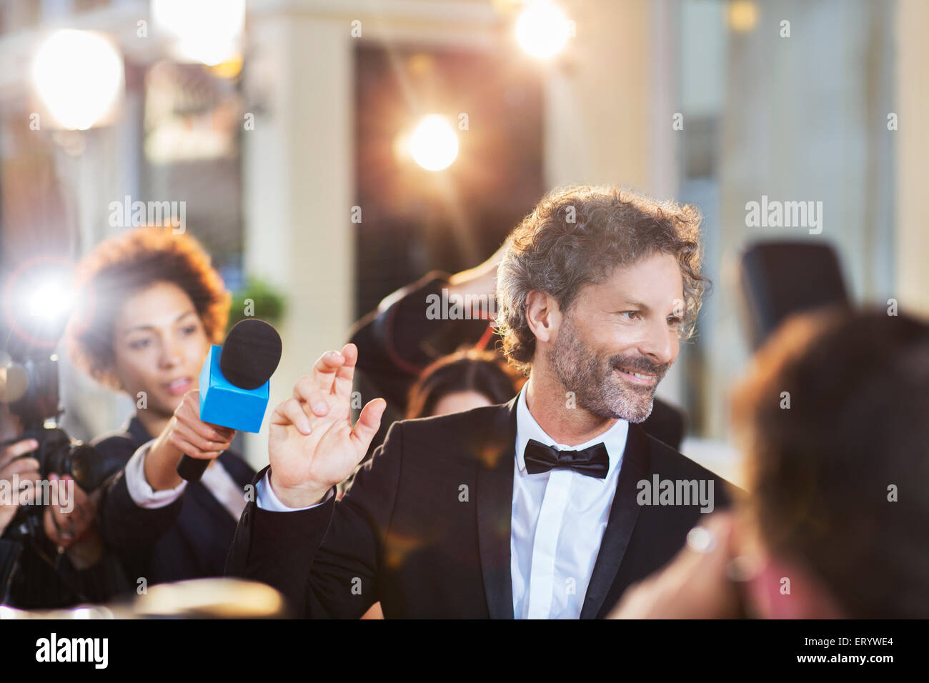 Celebrity waving to paparazzi at event Stock Photo - Alamy