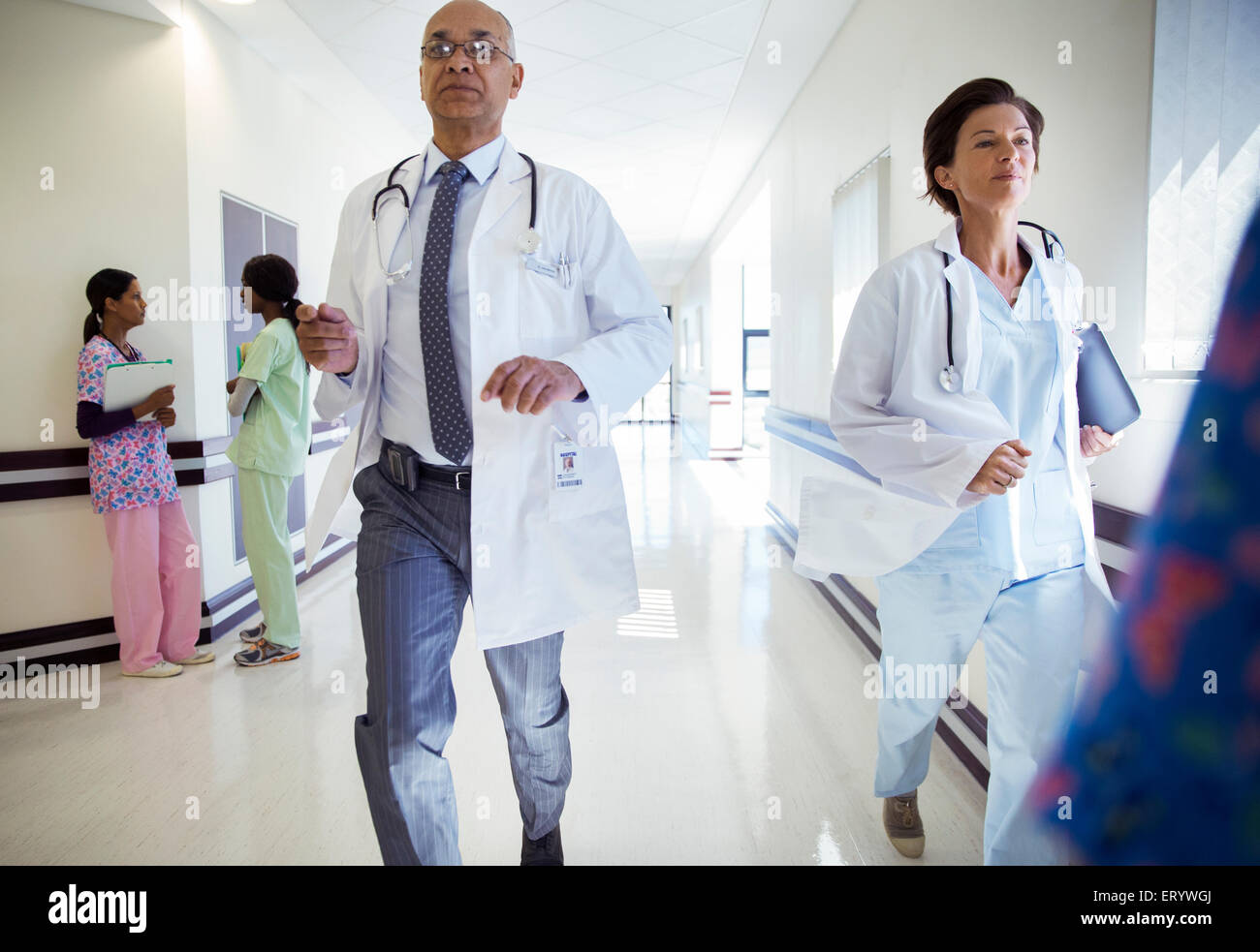 Doctors running down hospital corridor Stock Photo - Alamy