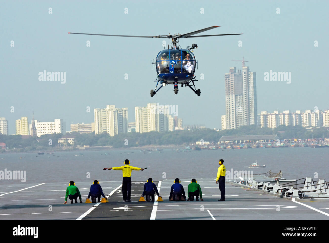 A runway controller indian navy guide chetak helicopter before landing ...