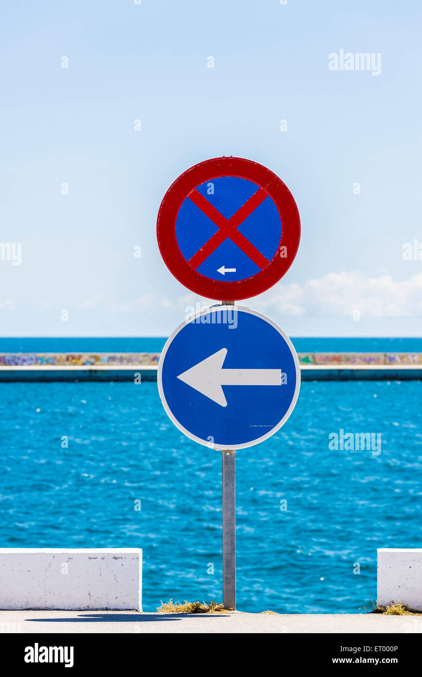 No parking sign and another sign of compulsory direction with the sea ...