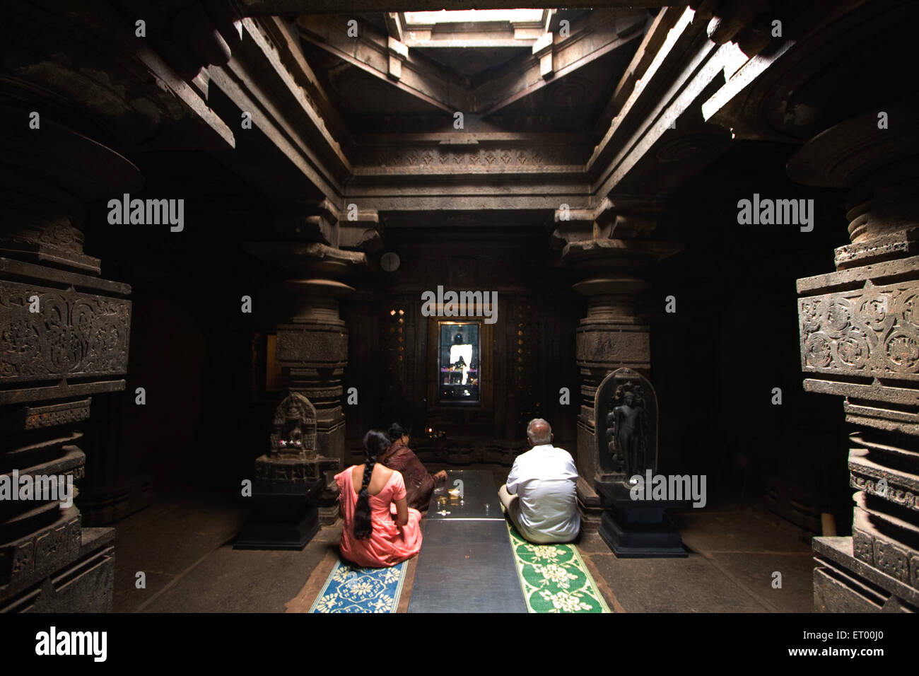 Man and woman praying in jain old temple kamal basti at Belgaum ...