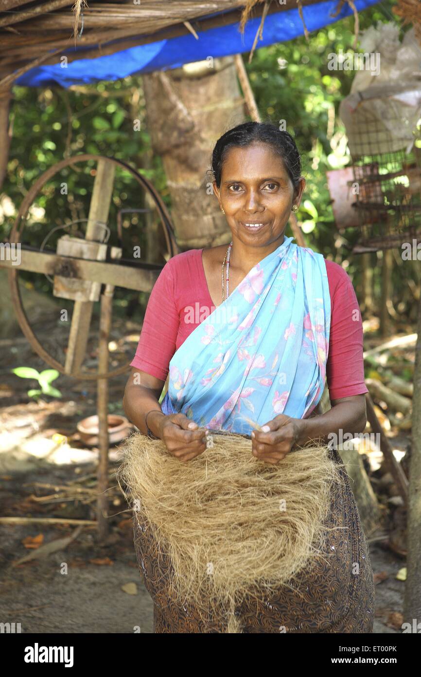 Keralite woman making coir rope in cottage ; traditional method ...