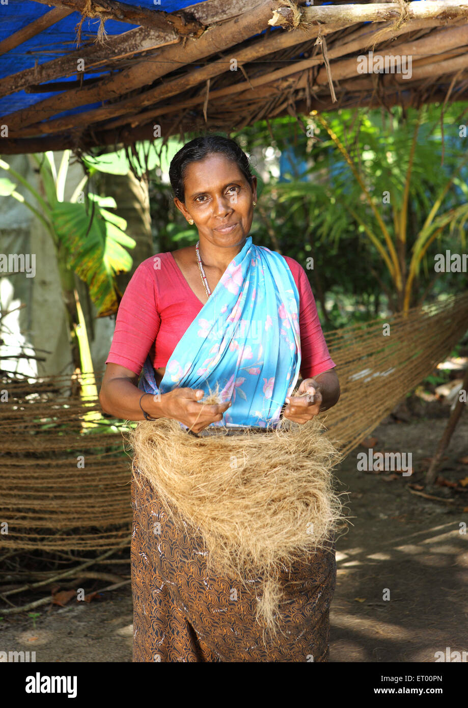 Keralite woman making coir rope in cottage ; traditional method ...