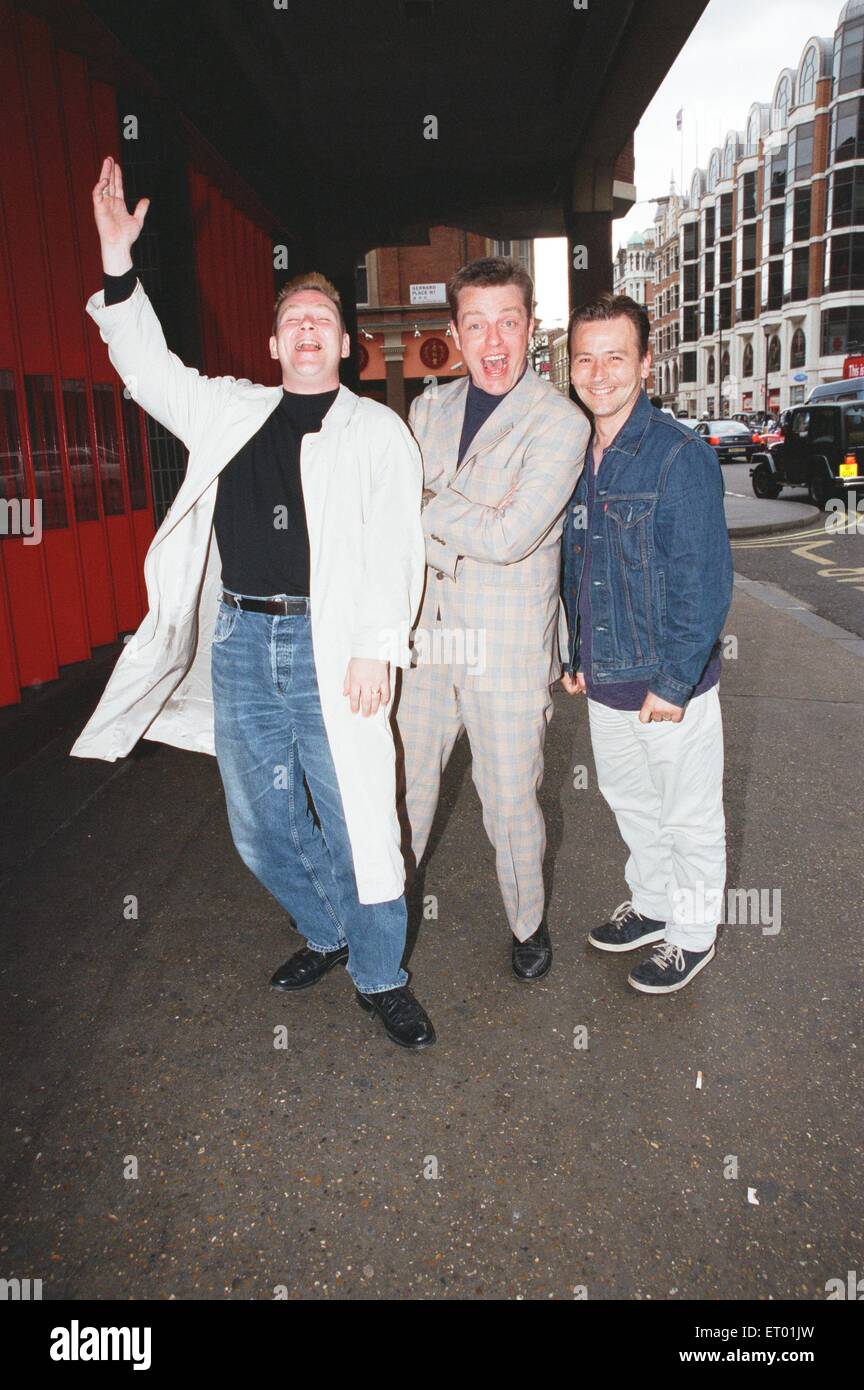 Suggs, lead singer of British ska group Madness, with two members of ...
