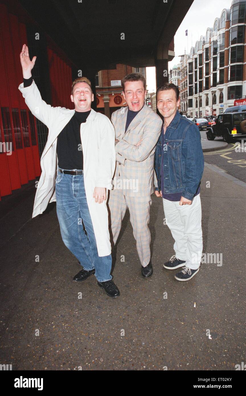 Suggs, lead singer of British ska group Madness, with two members of ...
