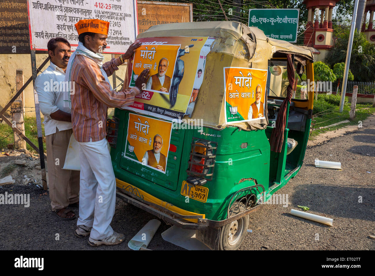 man sticking poster on Auto rickshaw Varanasi uttar pradesh india Asia ...