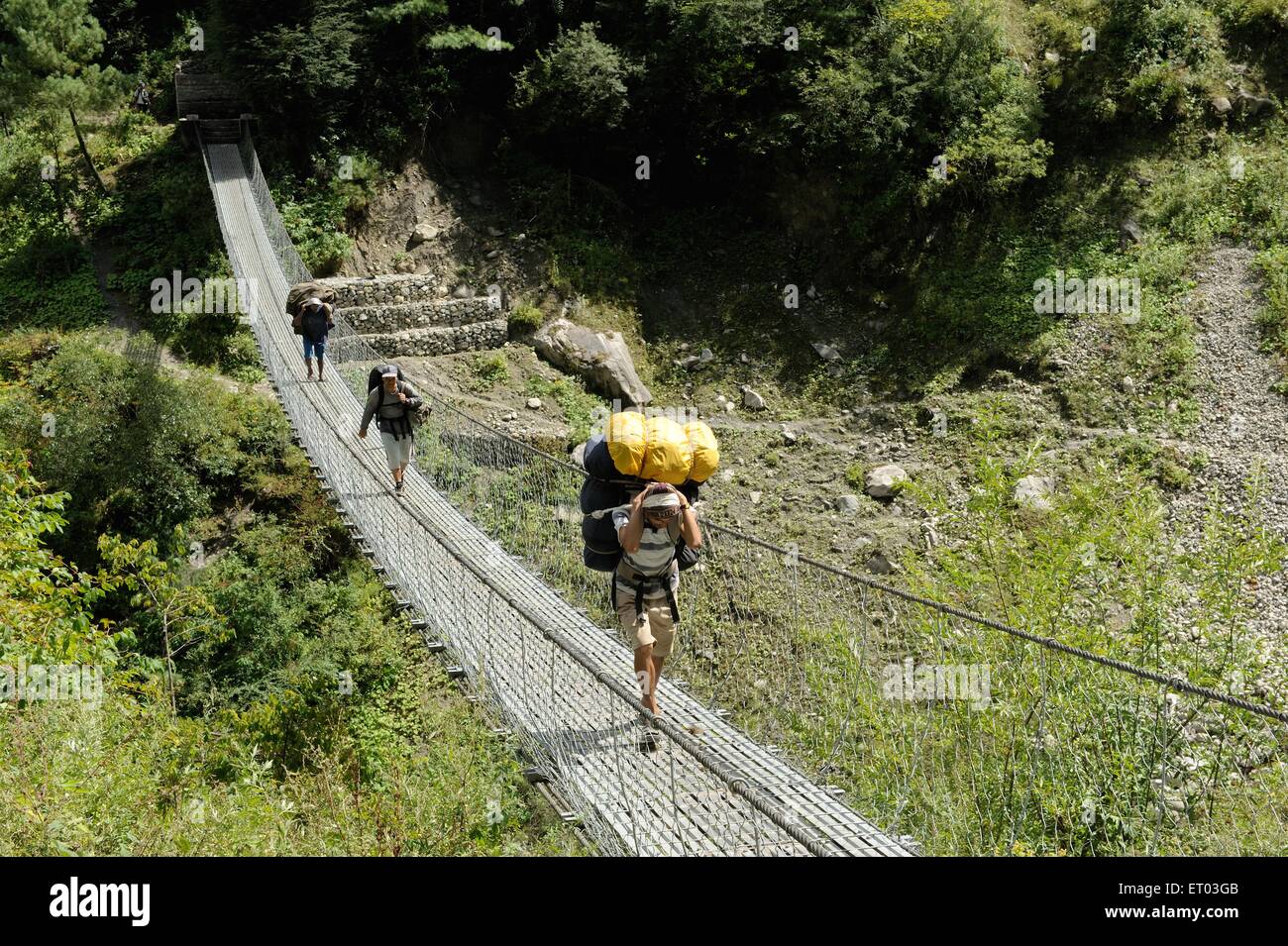 Porters crossing suspension bridge ,Thanchowk , Annapurna Circuit Trek ...