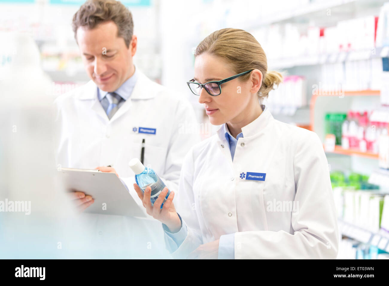 Pharmacist reading label on bottle in pharmacy Stock Photo - Alamy