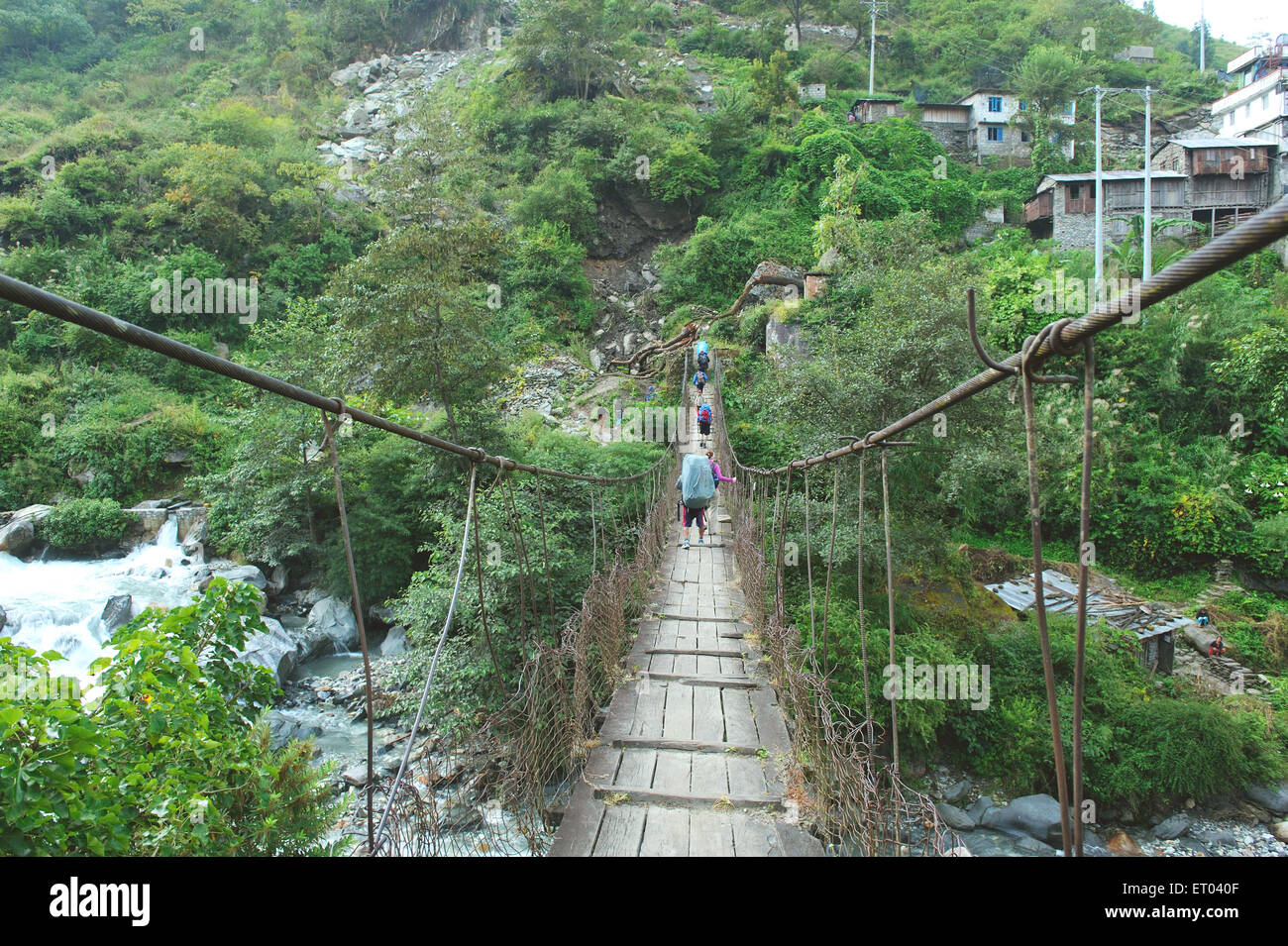 Trekkers crossing suspension bridge , Tatopani , Sindhupalchok ...