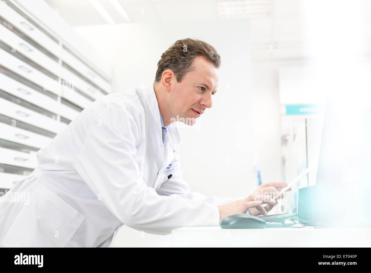 Pharmacist reviewing prescription in pharmacy Stock Photo - Alamy
