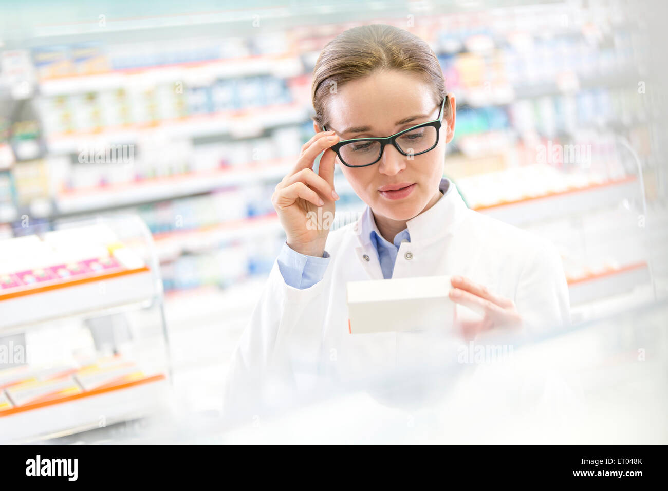 Pharmacist reading label on box in pharmacy Stock Photo - Alamy