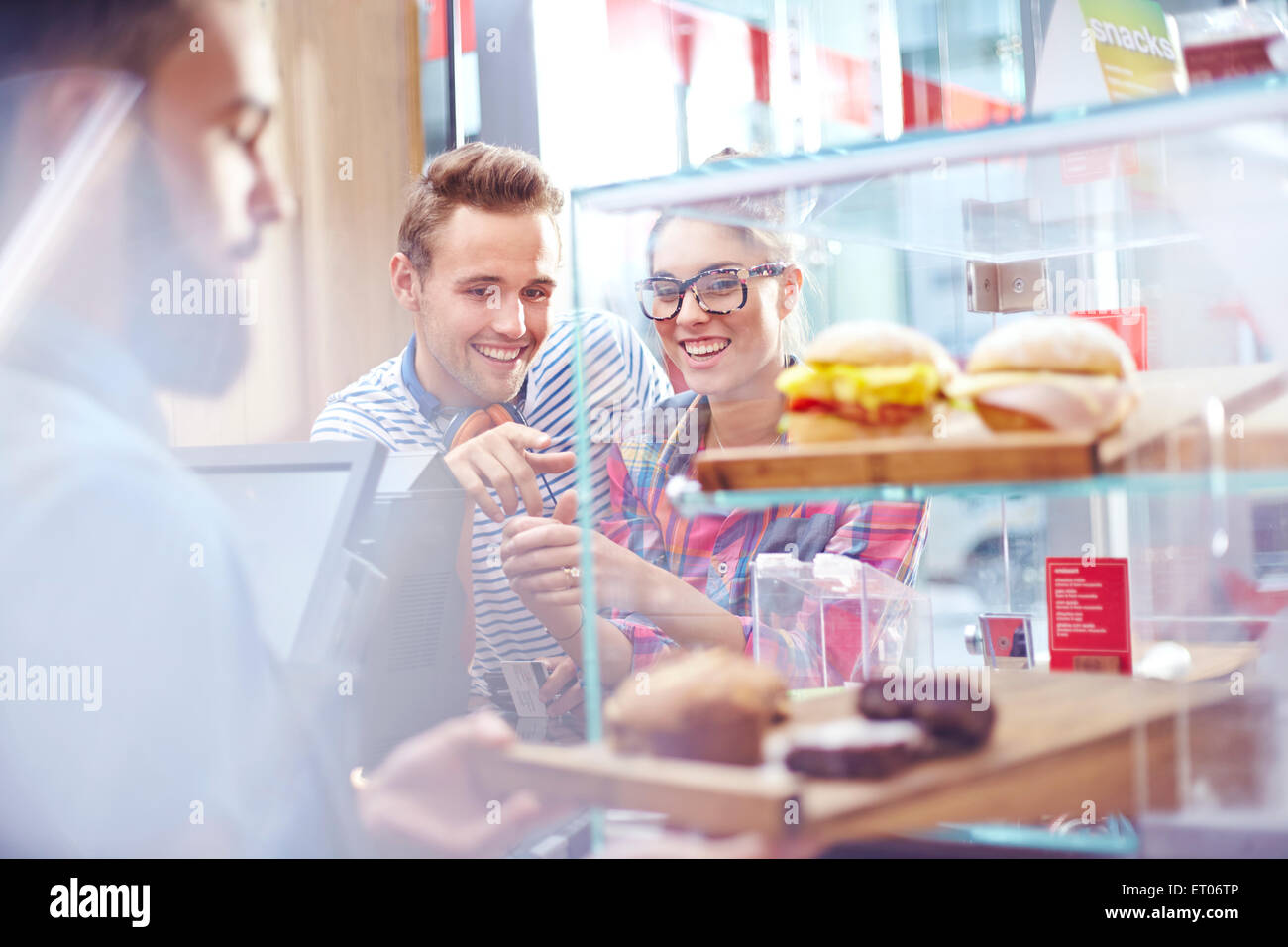 Couple choosing food at display case in cafe Stock Photo - Alamy
