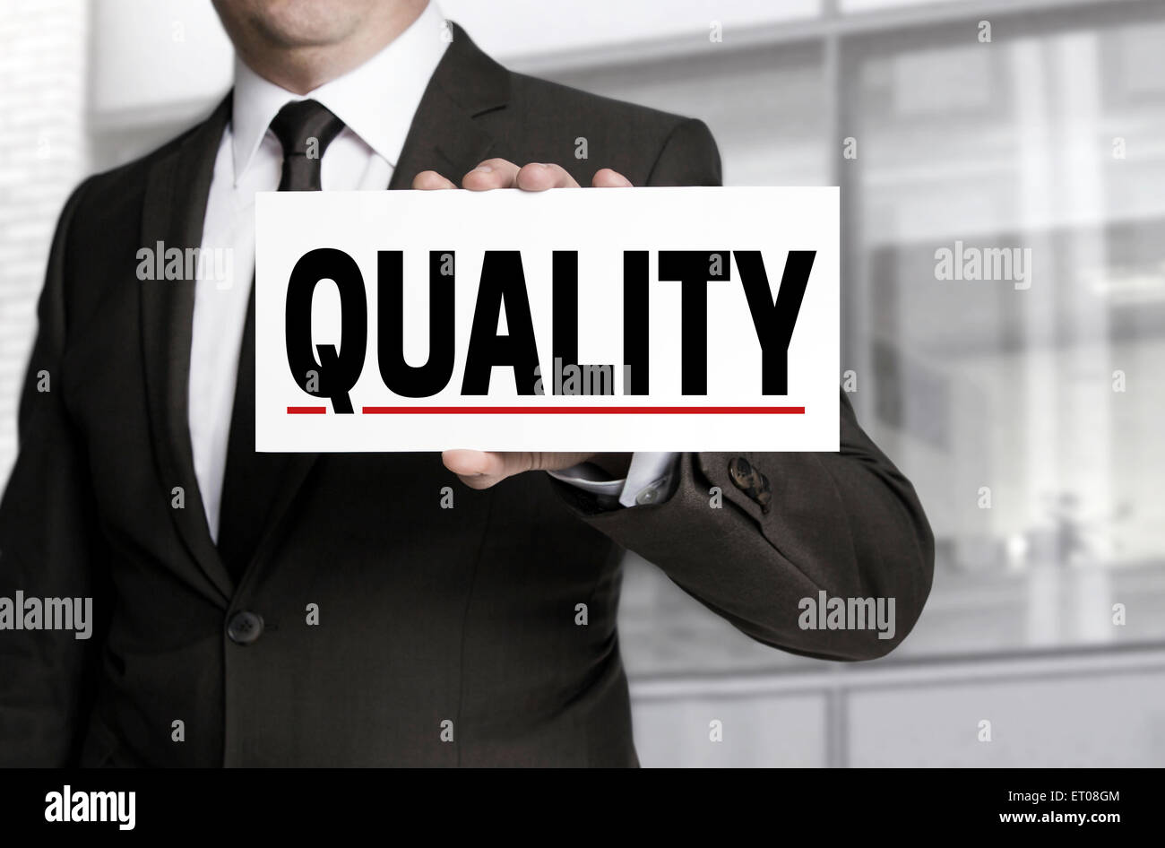 Quality sign is held by businessman Stock Photo - Alamy