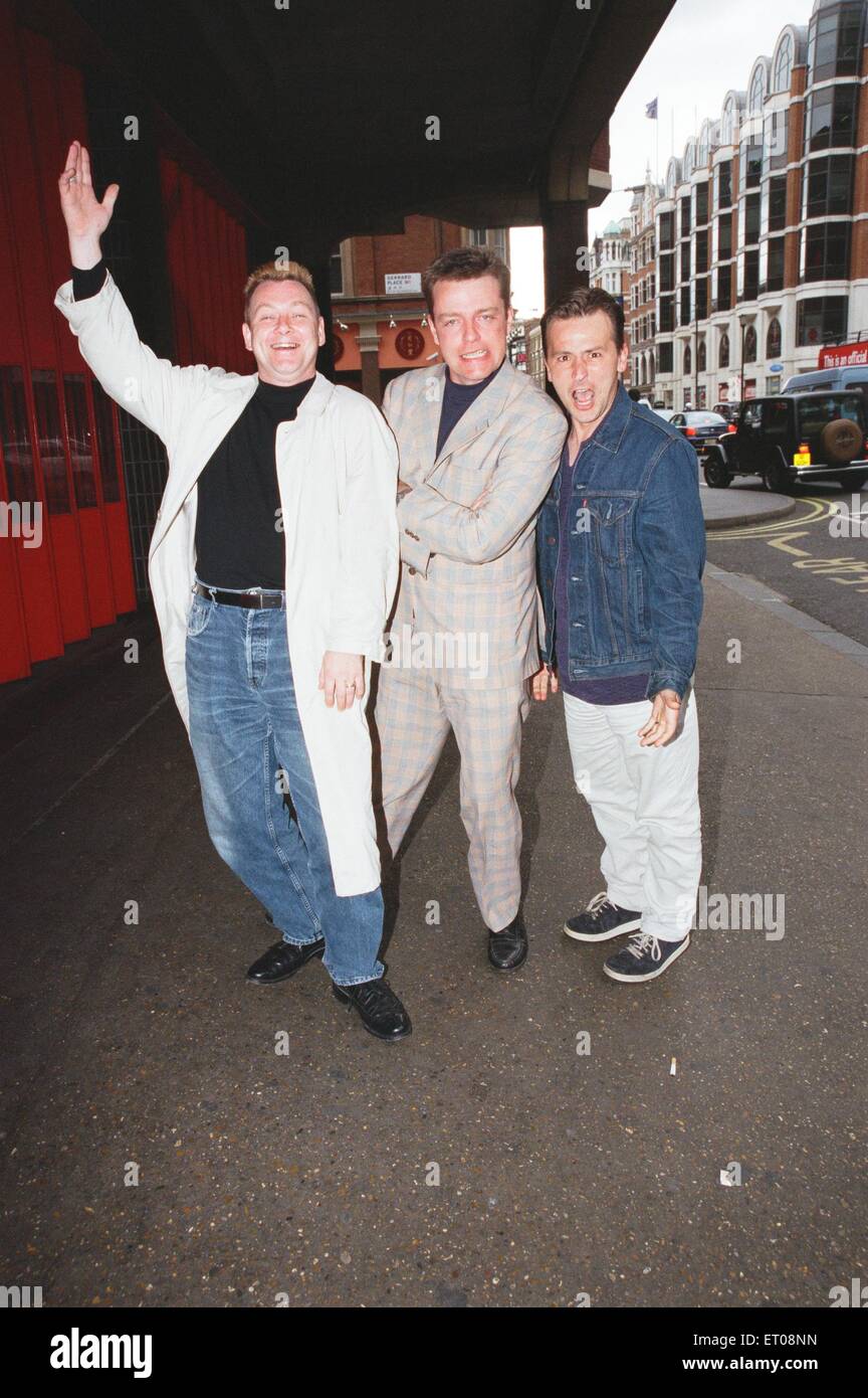 Suggs, lead singer of British ska group Madness, with two members of ...