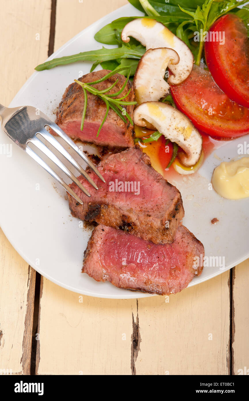 beef filet mignon grilled with fresh vegetables on side ,mushrooms tomato and arugula salad ...