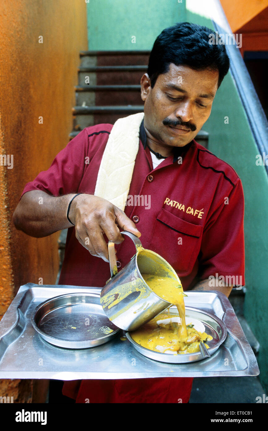 Waiter pouring sambar on idli in ratna cafe ; Madras Chennai ; Tamil ...