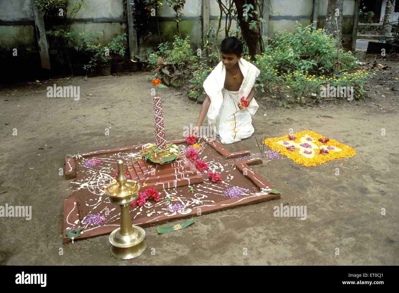 Boy making pookalm flower decoration Athappoovu during Onam festival ...