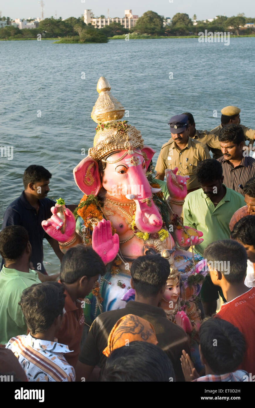 People carrying idol of lord ganesh immersing in pond on ganpati ...