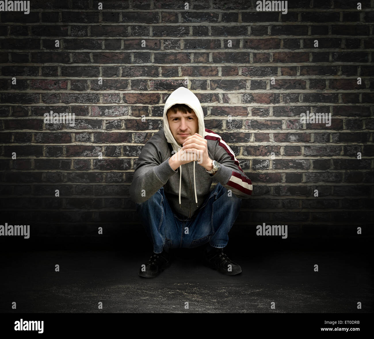 young man sits near a wall Stock Photo - Alamy