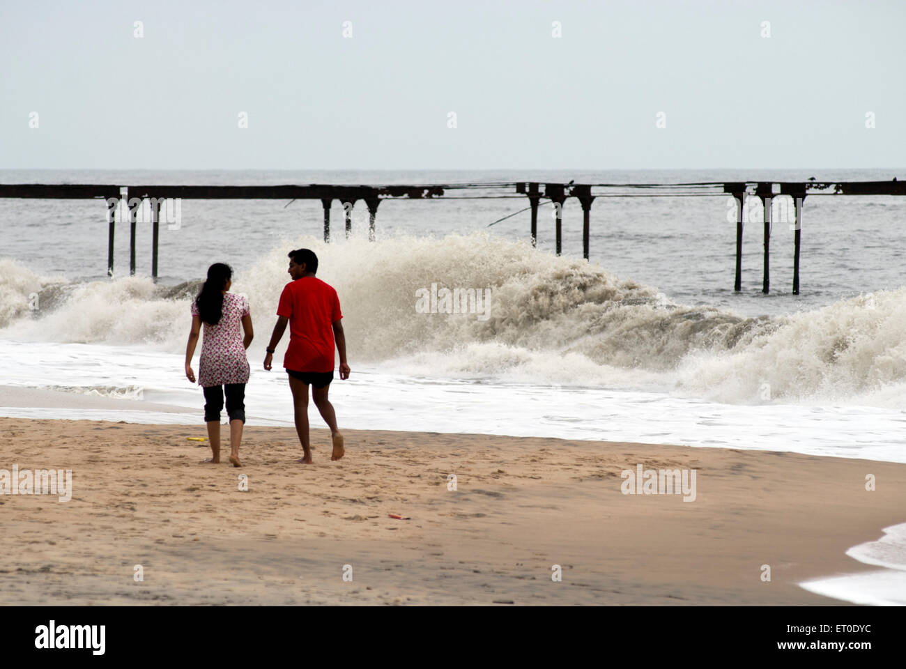 Couple walking on sand at Alleppey Alappuzha beach ; Kerala ; India MR ...