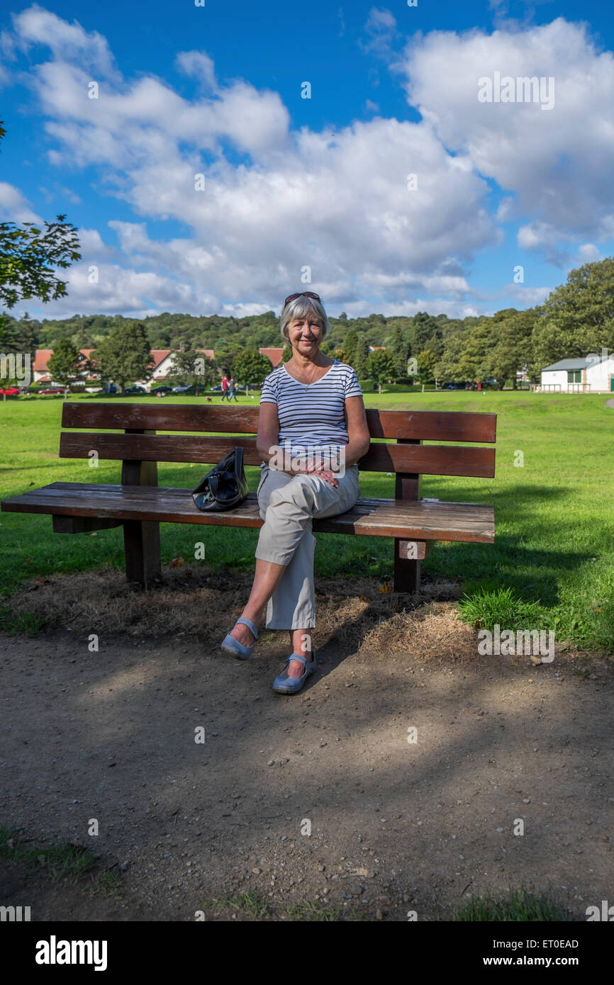 A female sat on a bench in the park soaking up the glorious sunshine ...