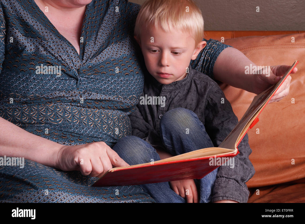 Story time in the couch, Woman reads the book to the little Child Stock ...
