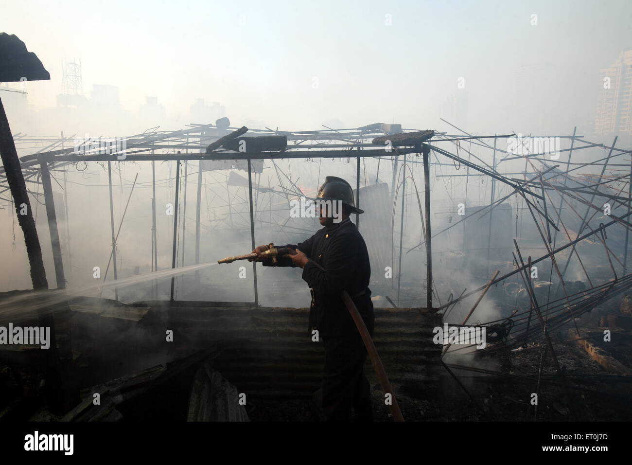 Fireman trying to douse off the fire which broke out at the Mhada ...