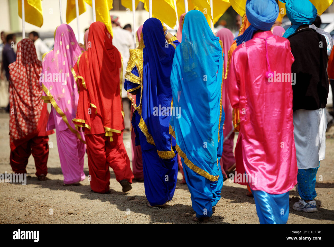 Young Sikhs in traditional attire holding flags ; cultural events ...
