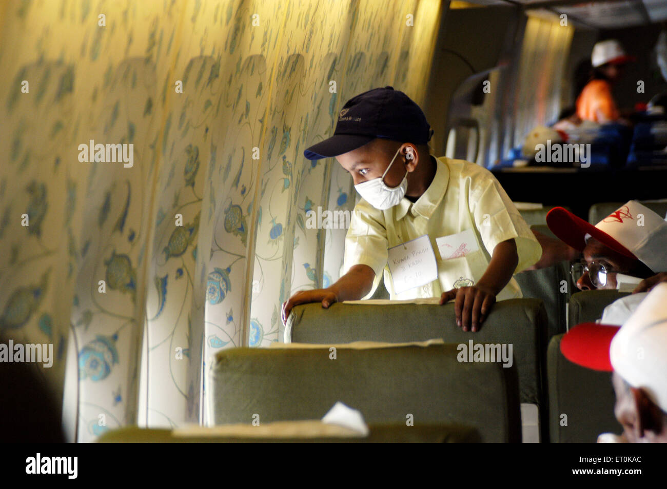 Young cancer patient looking out of aircraft window, Bombay, Mumbai ...
