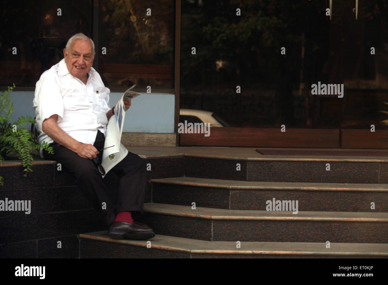 Senior Tata Officer Rusy Modi with newspaper sitting at stairs of his ...