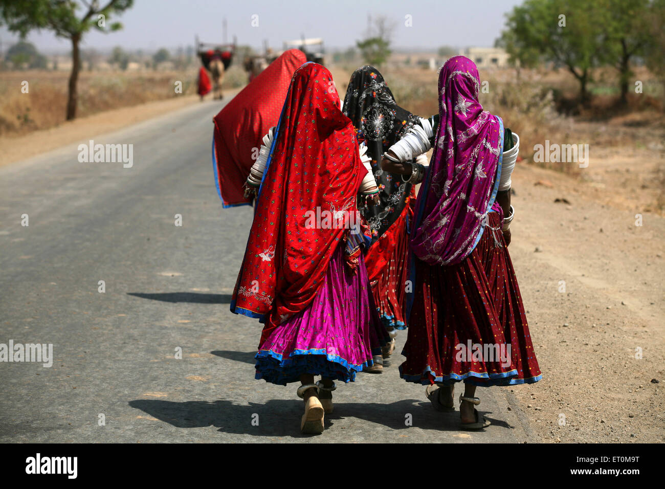 Nomad women in traditional colourful dress with lots of jewellery seen ...