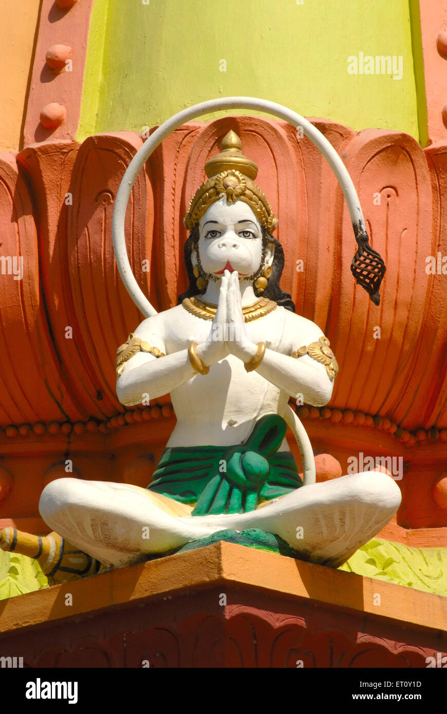 Colourfully painted stucco figure lord Hanuman sitting Namaskar posture ...