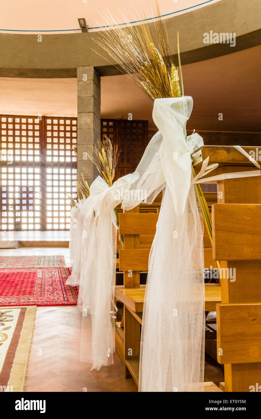 Entry of Italian Catholic church with benches decorated with spring ...