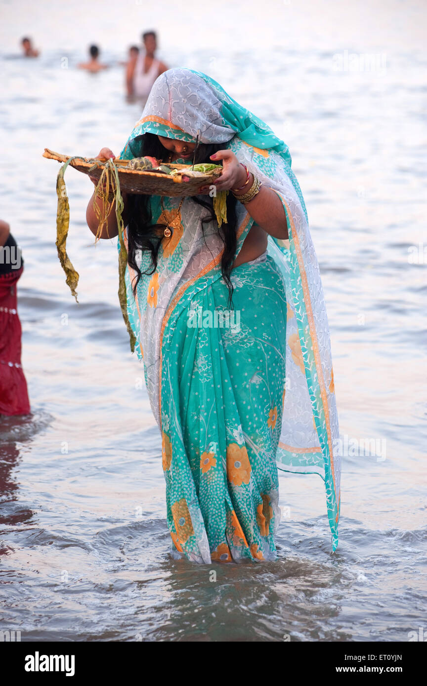 Woman worshipping sun dala chhath at juhu ; Bombay Mumbai ; Maharashtra ...