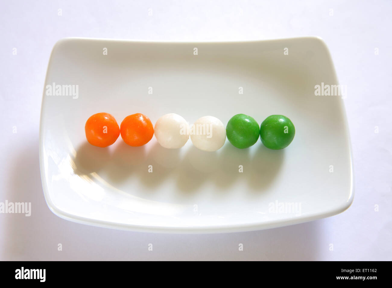 Colourful sweet and sour ball or marble in rectangle plate on white ...