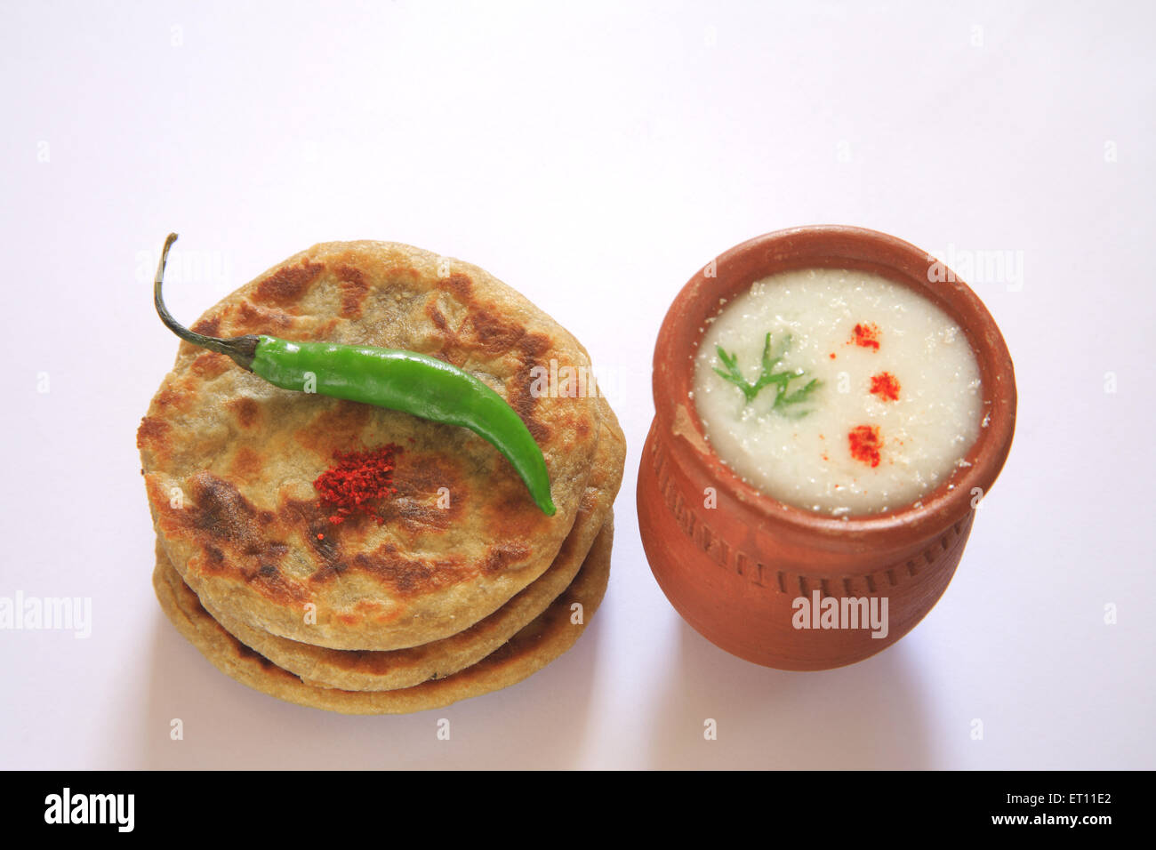 Bhakri jowar bread with green chilli and buttermilk in earthen pot on ...