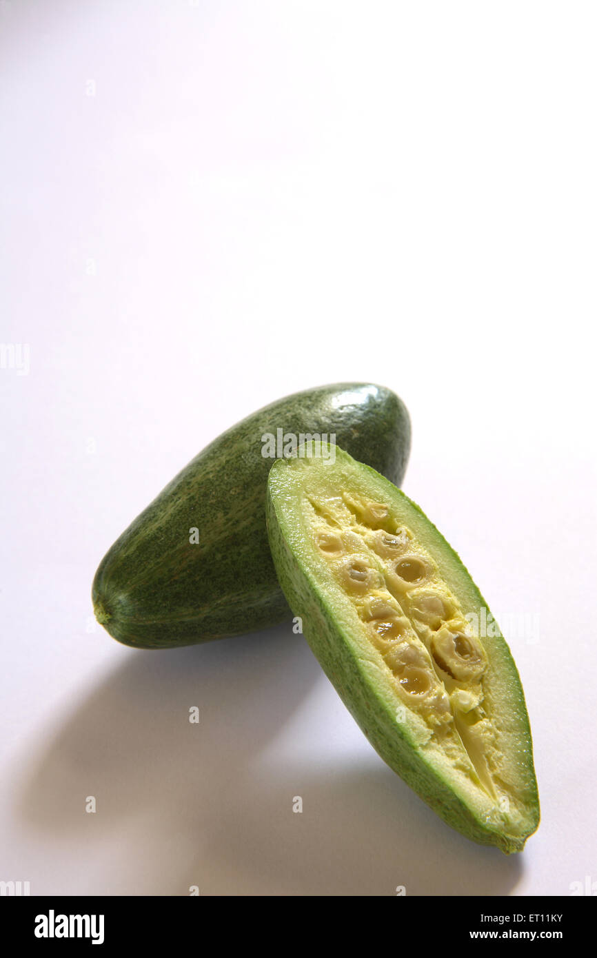 Vegetable ; one full and half striped pear gourds parwal on white ...